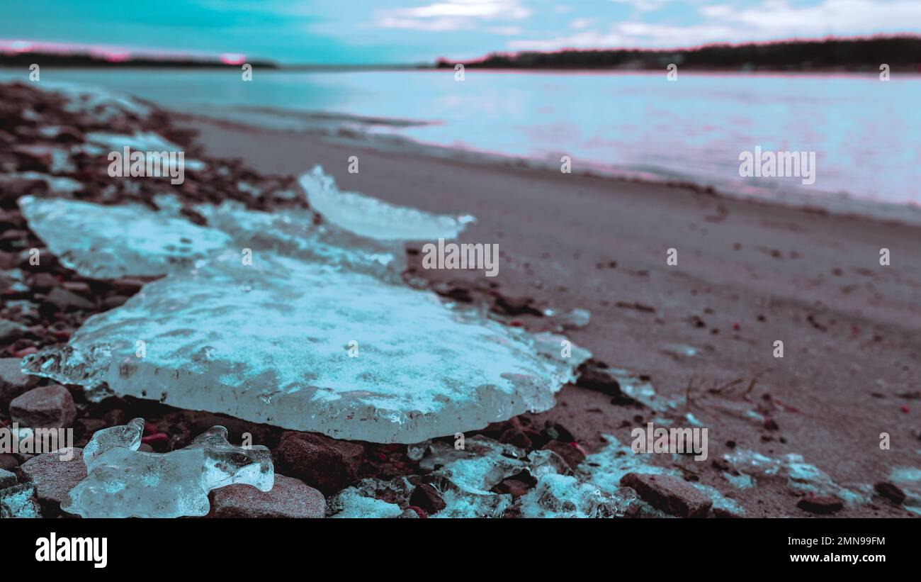 Small glaciers of the first ice lie on the sandy bank of the Vilyui ...