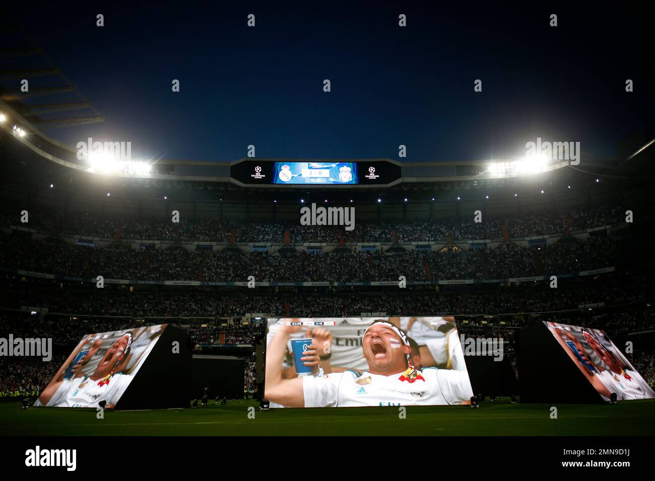 Real Madrid supporters celebrate a goal as they watch on big screens ...