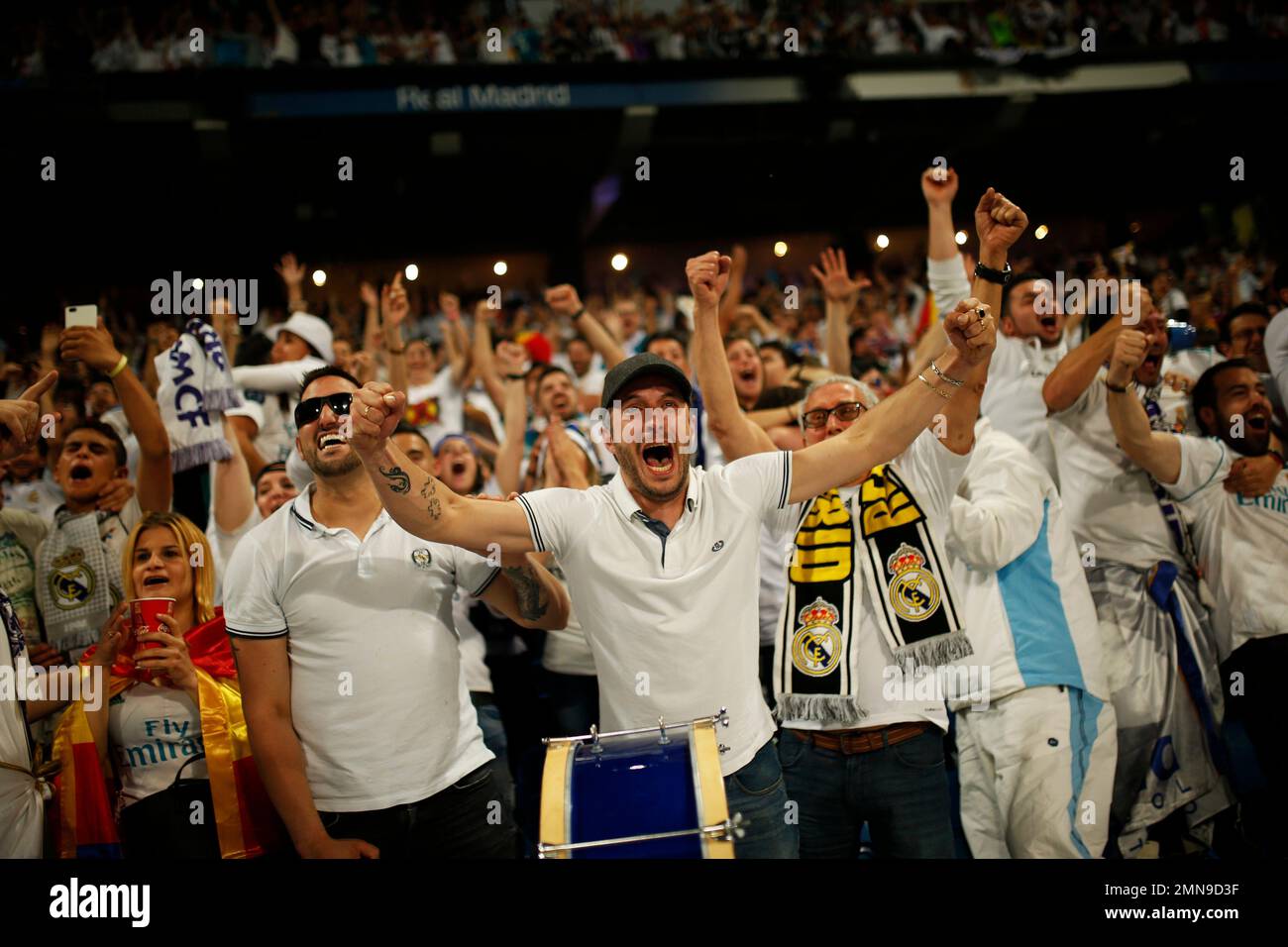 Real Madrid supporters celebrate a goal as they watch on big screens ...