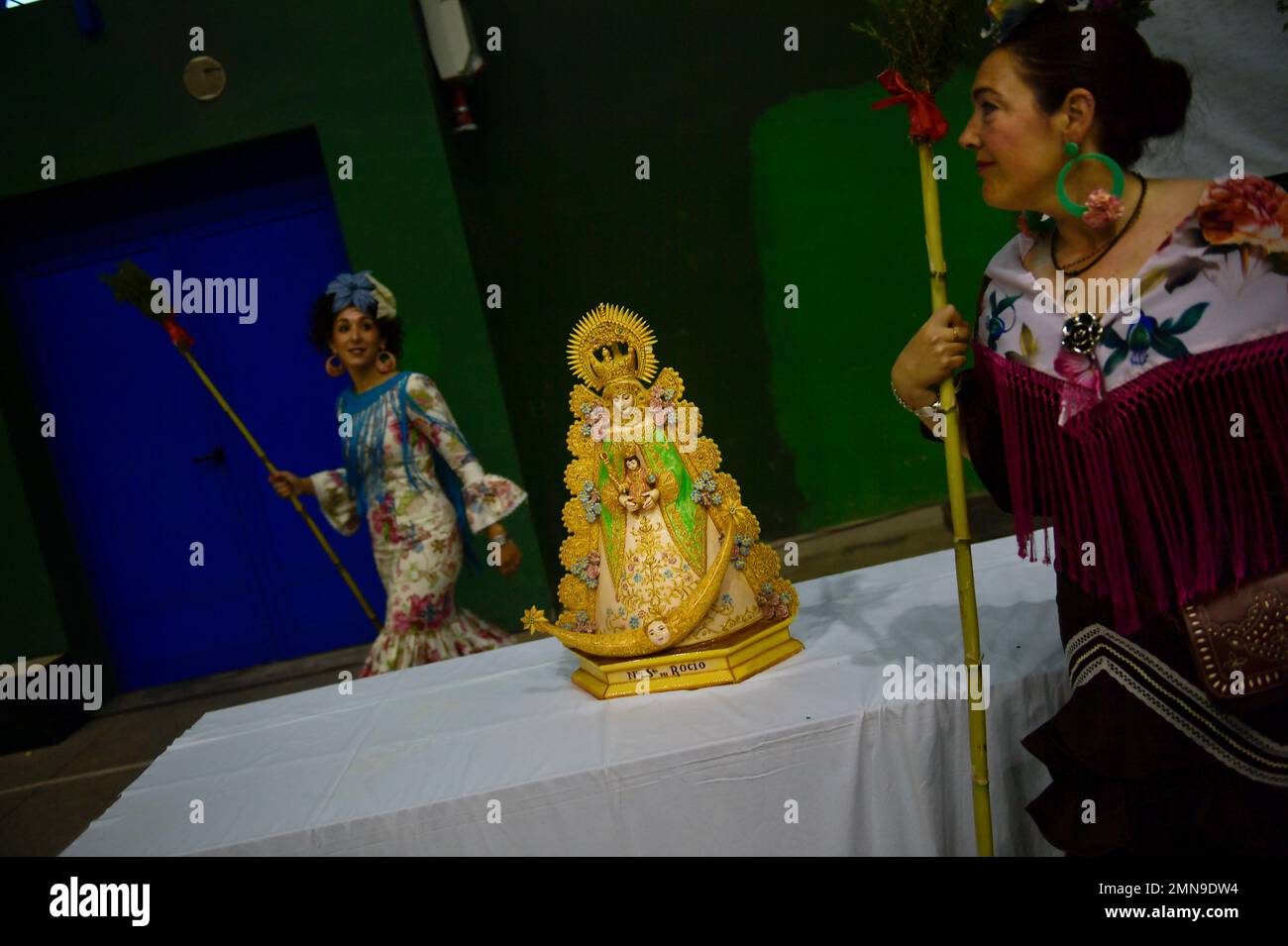 Devotees of the Rocio Virgin, dressed in traditional outfits, walk by a ...