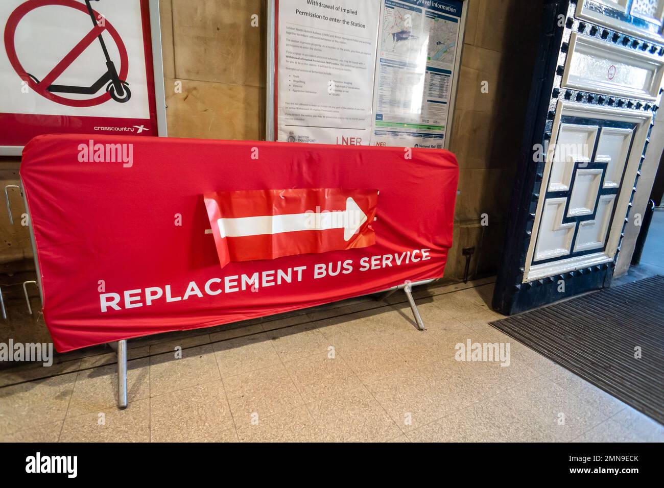 A red sign on a barrier shows commuters at the train station where to ...