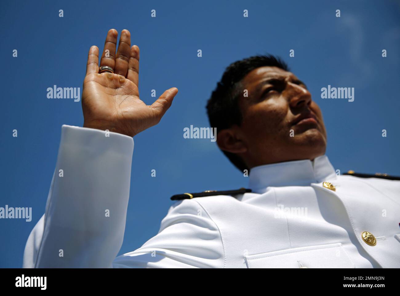 A U.S. Naval Academy midshipman raises his right hand as he is ...