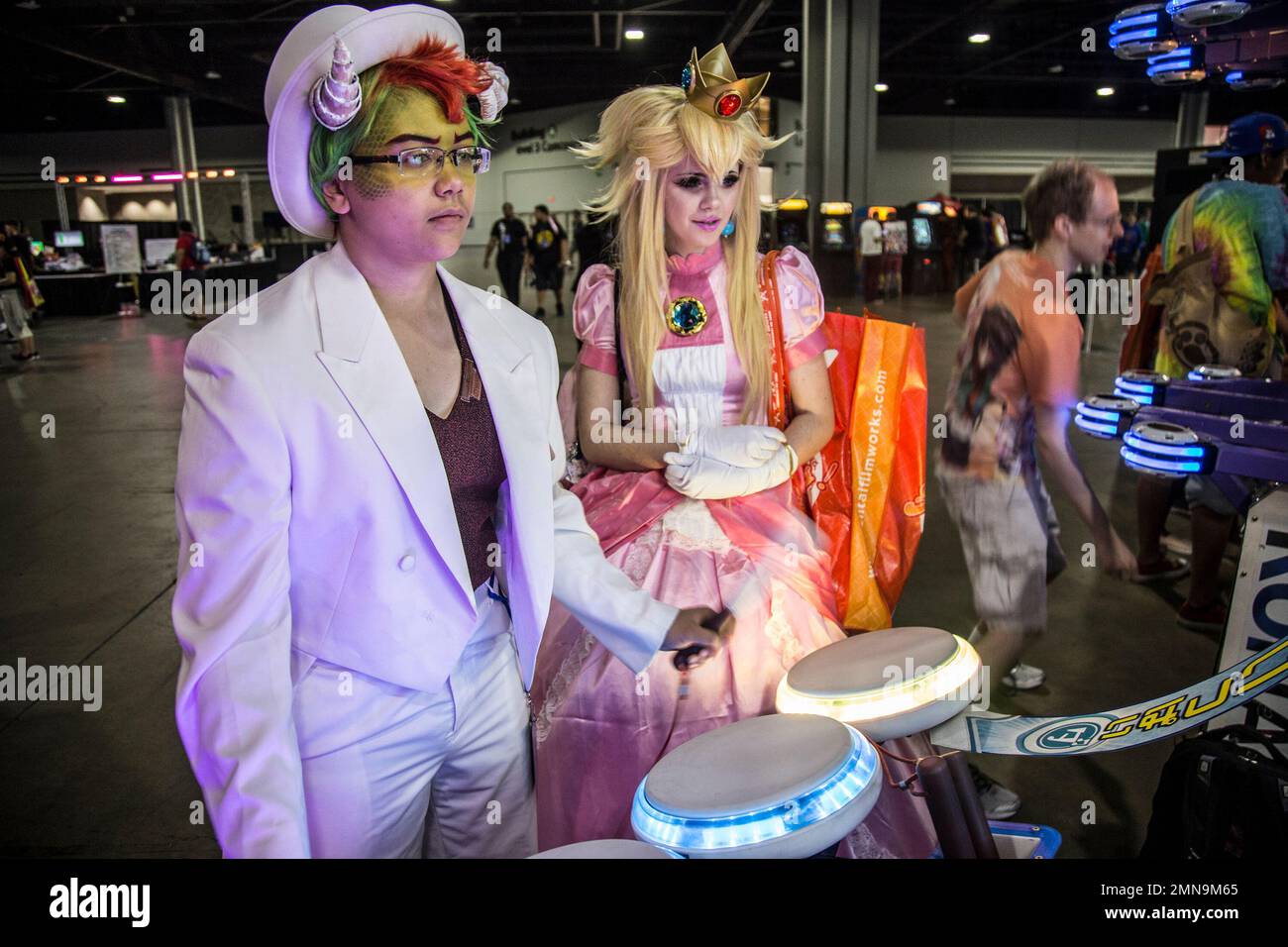 Two MomoCon attendees play a drumming-based video game Thursday, May 24 ...
