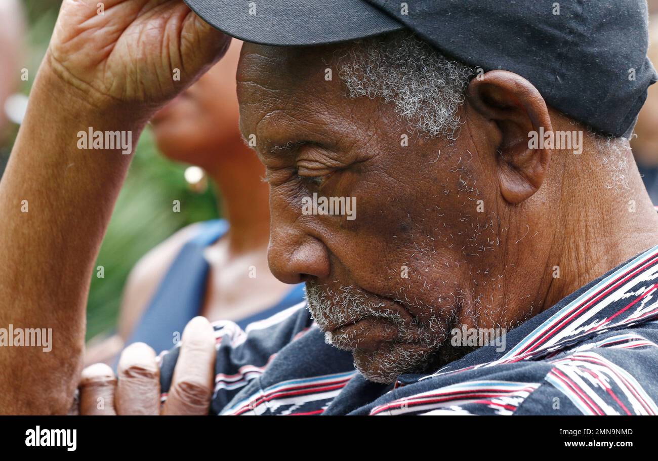 Charles Evers doffs his hat as an invocation is given during the ...