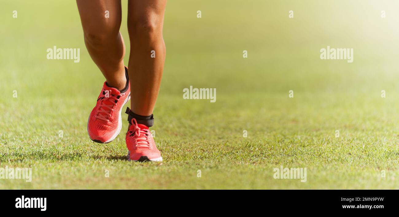Runner athlete feet running on grass. Female fitness sunlight jogging ...