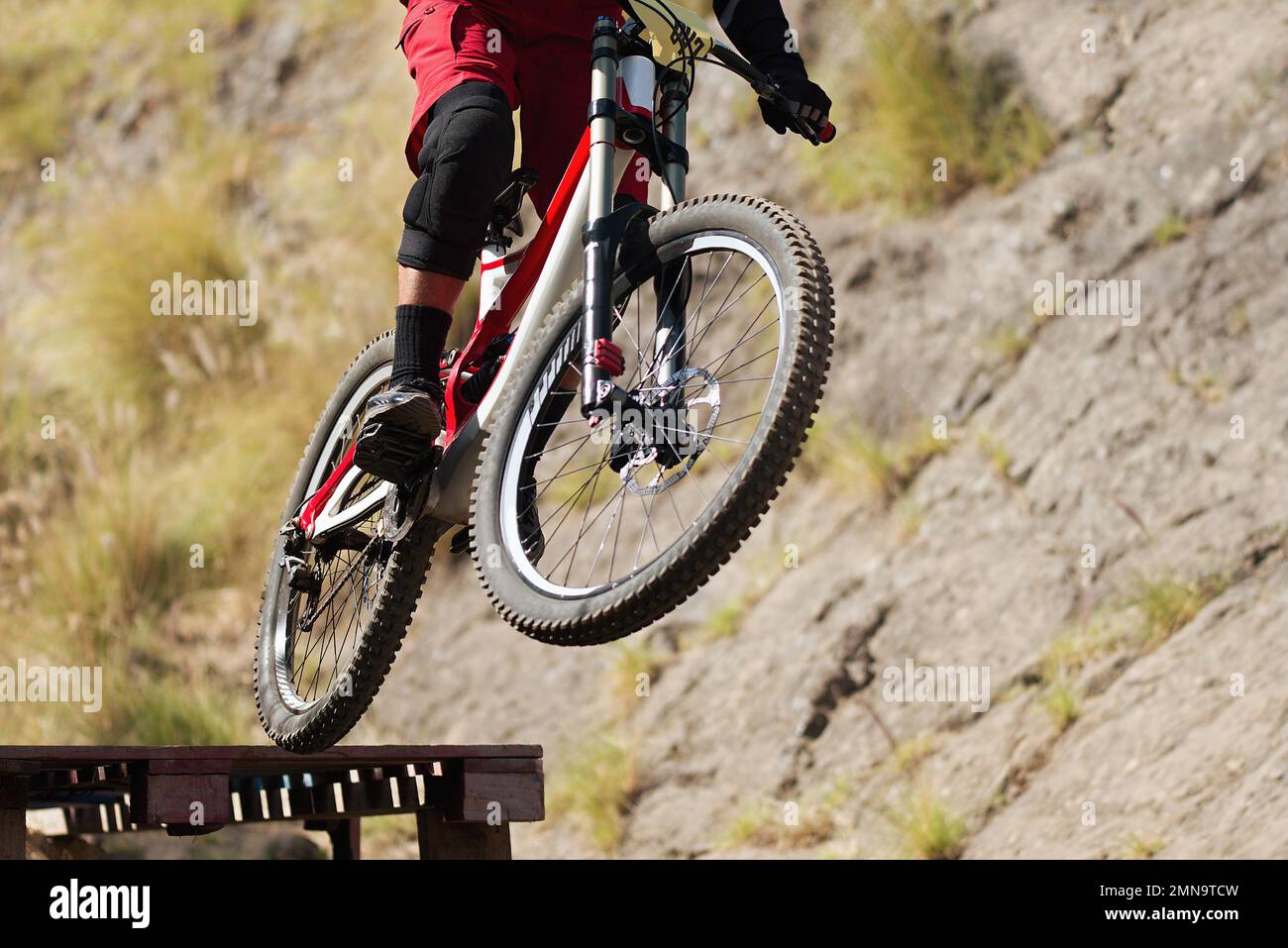 Professional athlete high jumping downhill on the mountain bike cross ...
