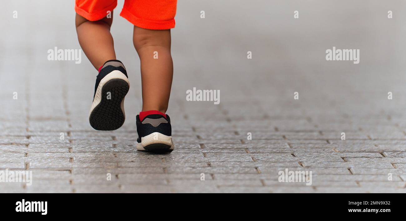 Kid runner feet running on the road in the park, fitness baby running ...