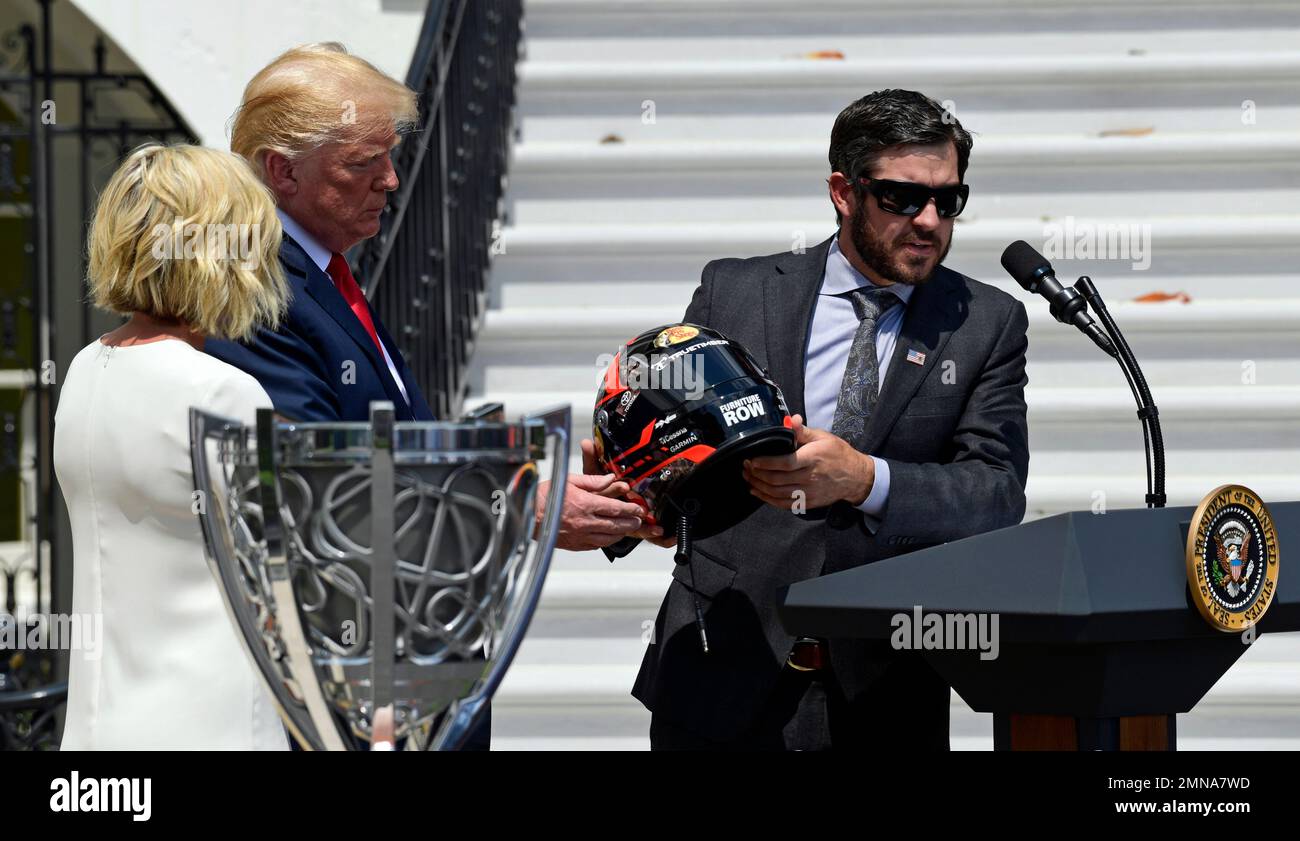 President Donald Trump, center, is presented with a replica helmet from ...