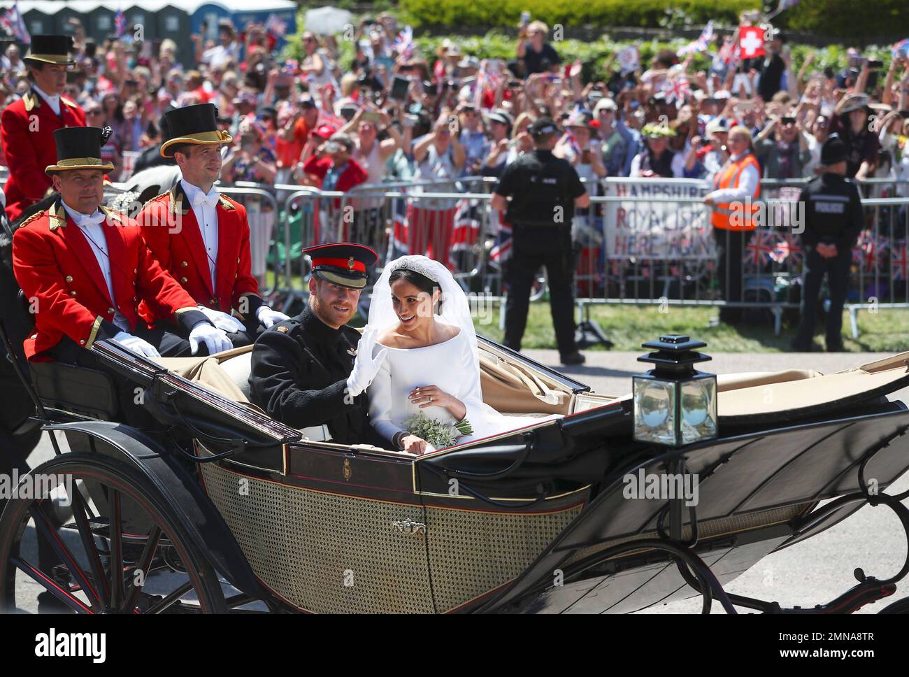 Britain's Prince Harry and his wife Meghan Markle ride a horse-drawn ...