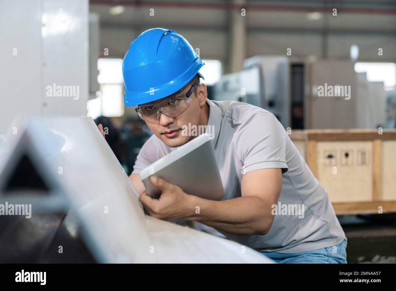 Engineer wearing a helmet use tablet computers work in a factory Stock ...