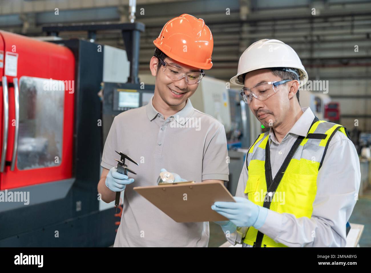 Two engineers wear protective overalls wearing helmets working in the ...