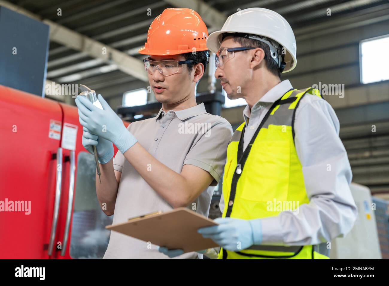 Two engineers wear protective overalls wearing helmets working in the ...