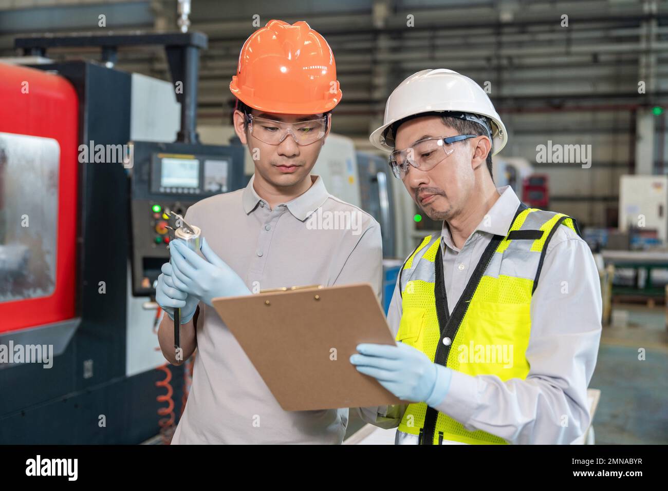 Two engineers wear protective overalls wearing helmets working in the ...