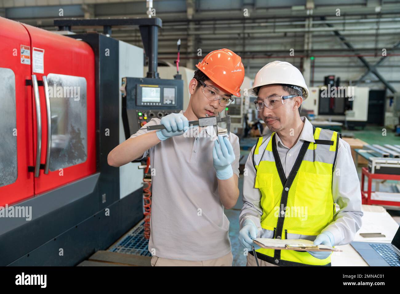 Two engineers wear protective overalls wearing helmets working in the ...
