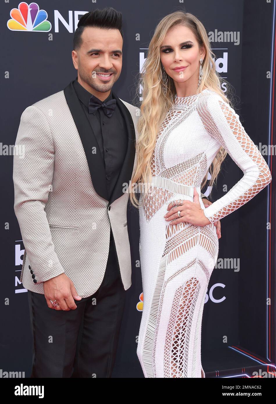 Luis Fonsi, left, and Agueda Lopez kiss as they arrive at the Billboard ...