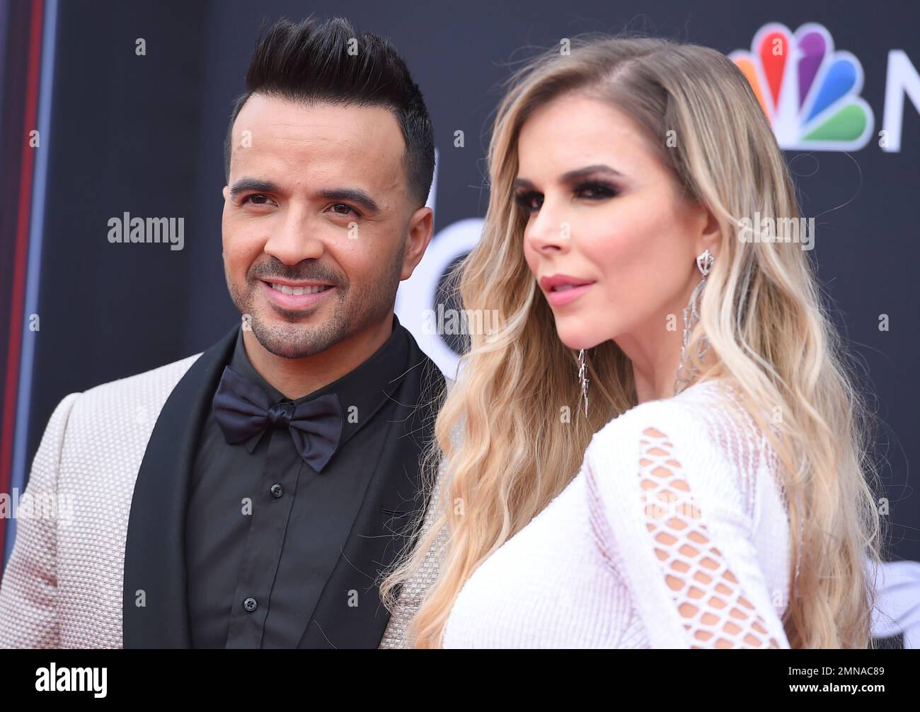Luis Fonsi, left, and Agueda Lopez kiss as they arrive at the Billboard ...