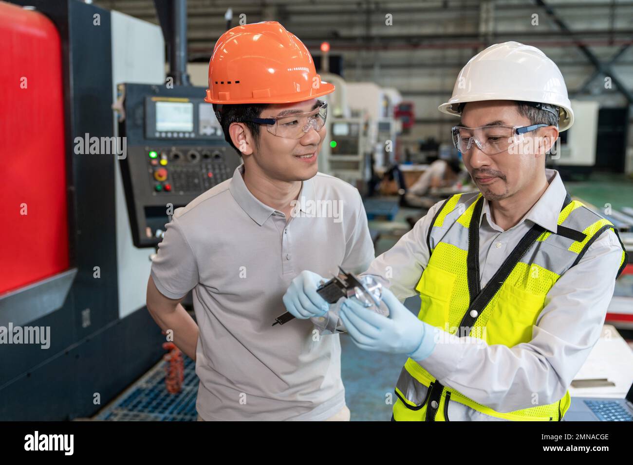 Two engineers wear protective overalls wearing helmets working in the ...