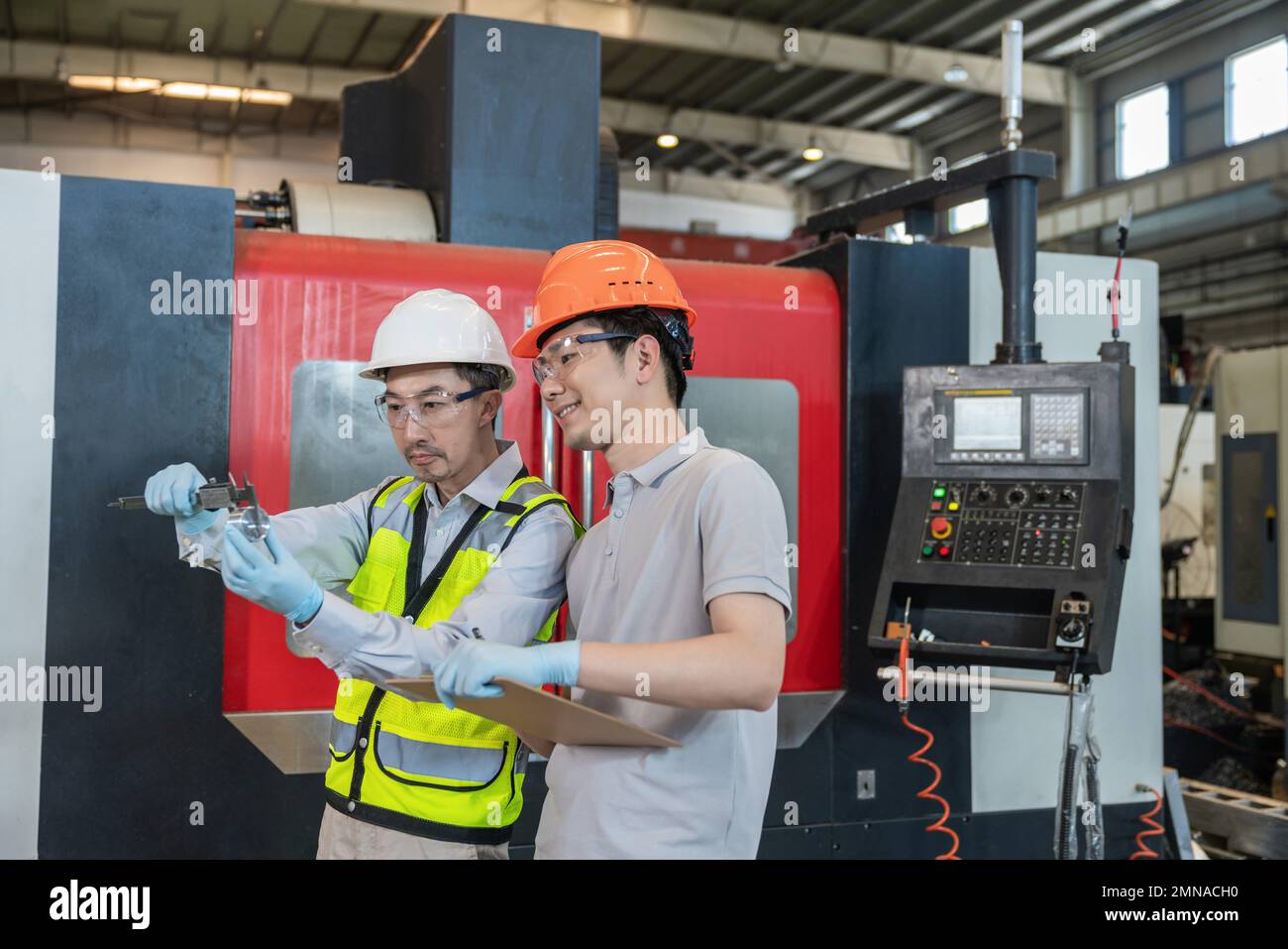Two engineers wear protective overalls wearing helmets do measurement ...