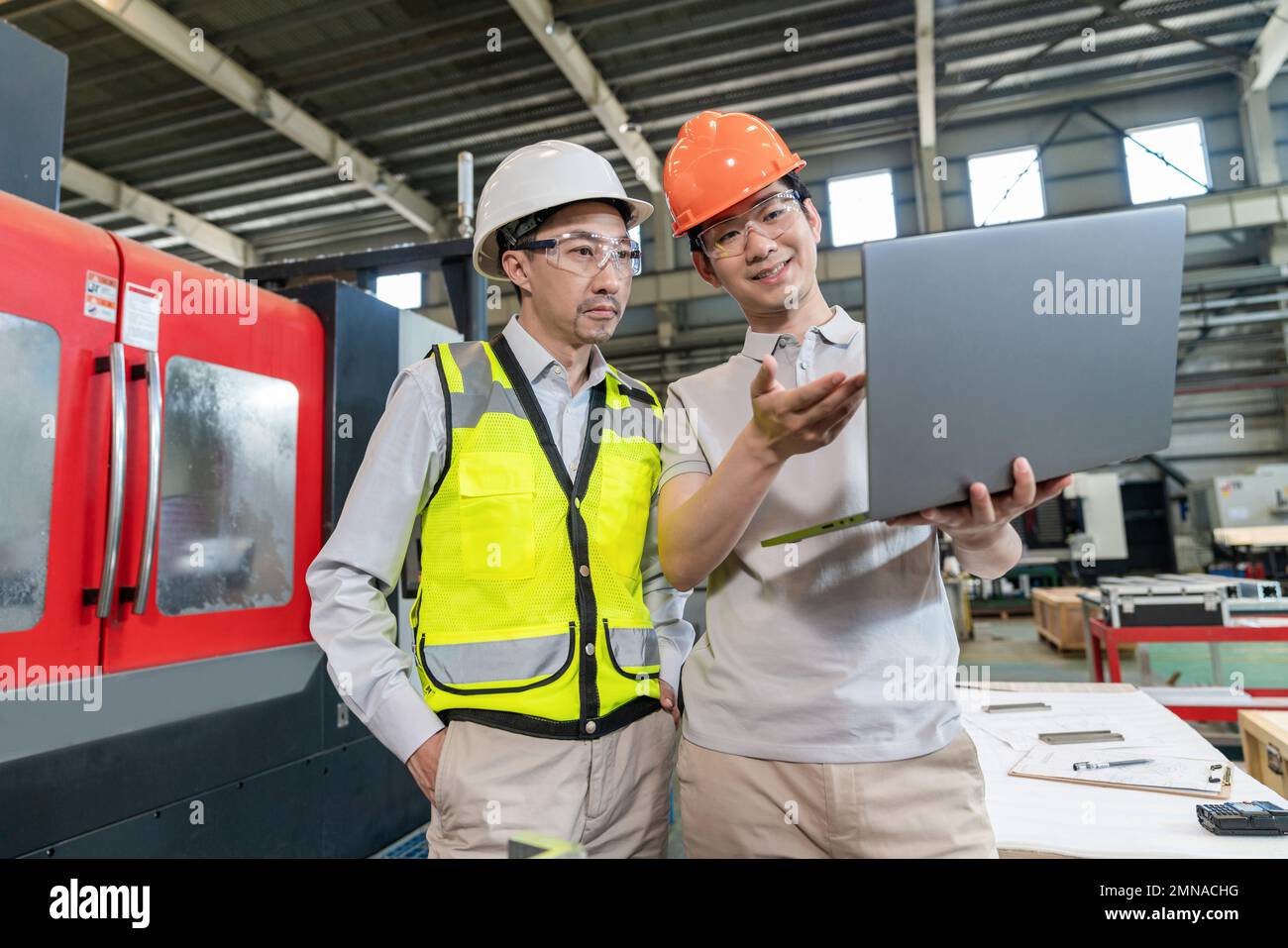 Two engineers wear protective overalls wearing helmets working in the ...