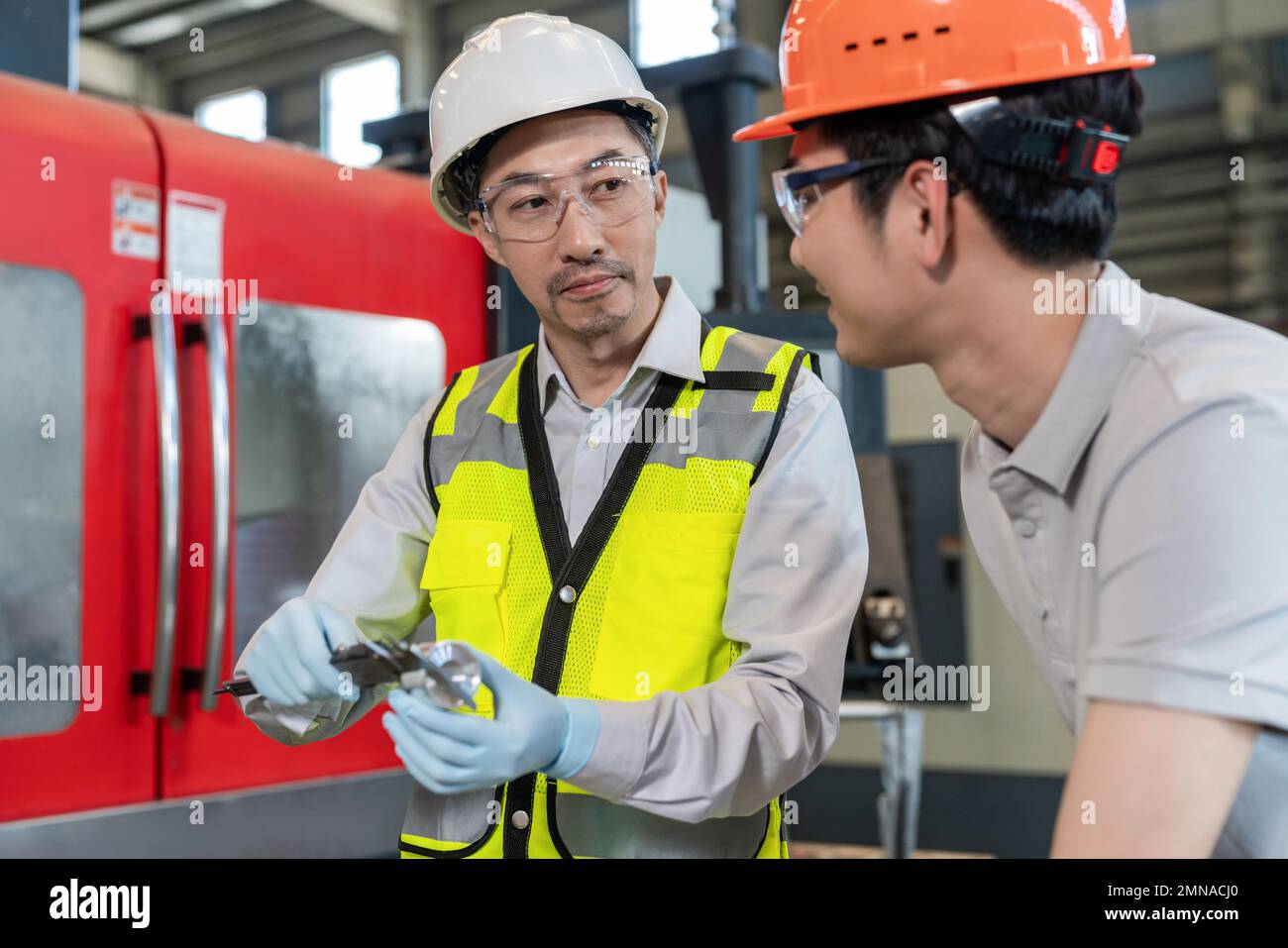 Two engineers wear protective overalls wearing helmets working in the ...