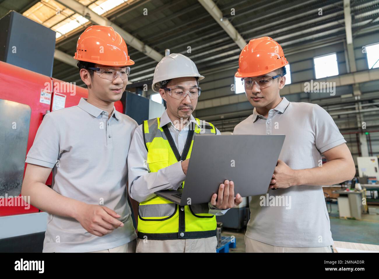 Three engineers wear protective overalls wearing helmets working in the ...