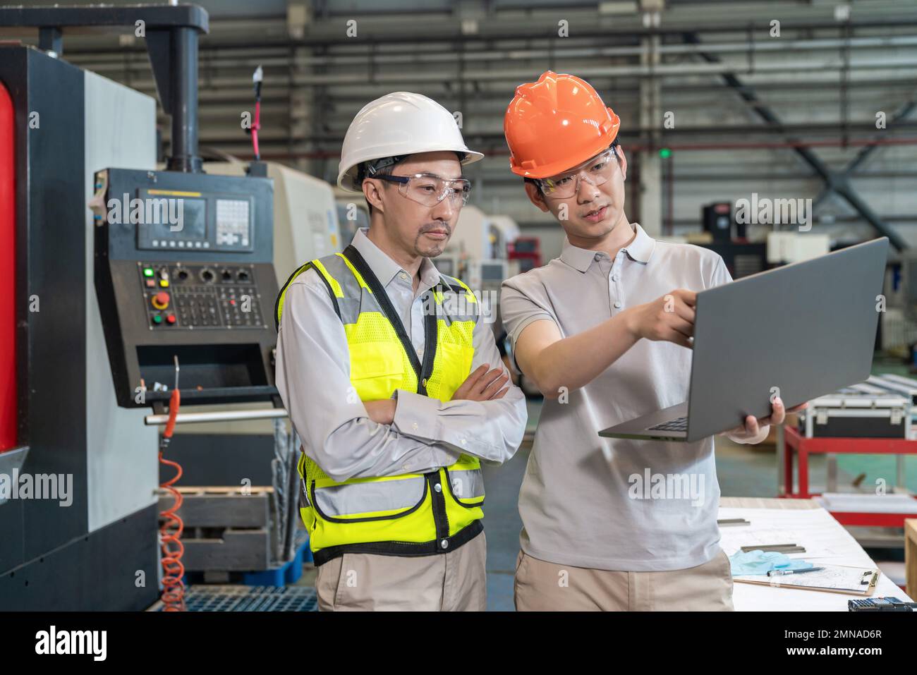 Two engineers wear protective overalls wearing helmets working in the ...
