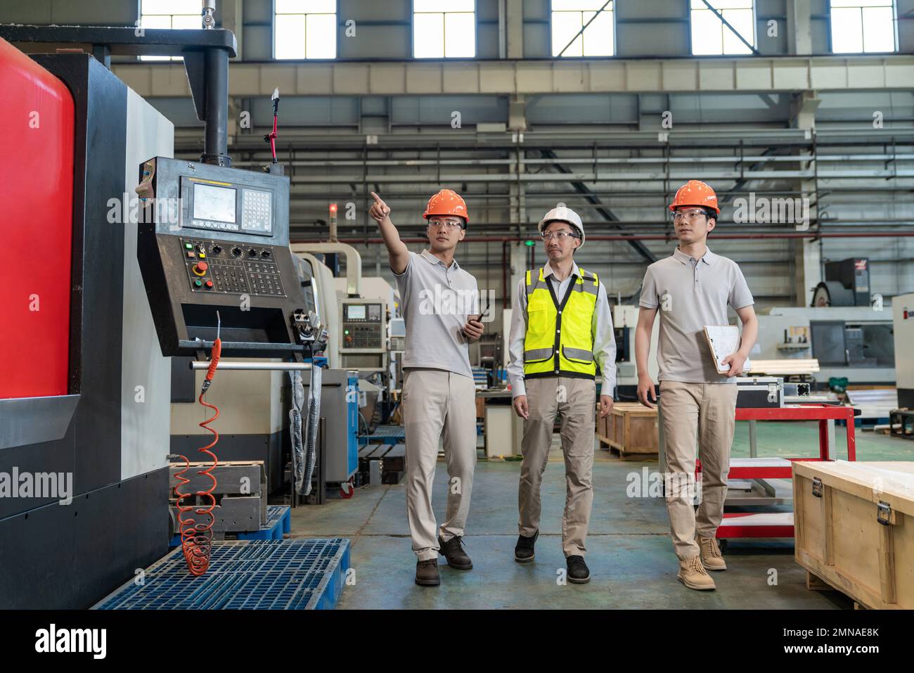 Three engineers wear protective overalls wearing helmets working in the ...
