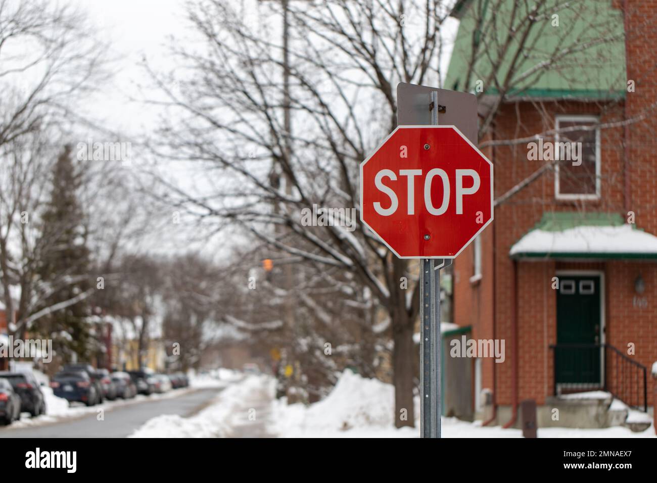 Stop sign in a residential neighborhood at crossroads in winter. Cars ...