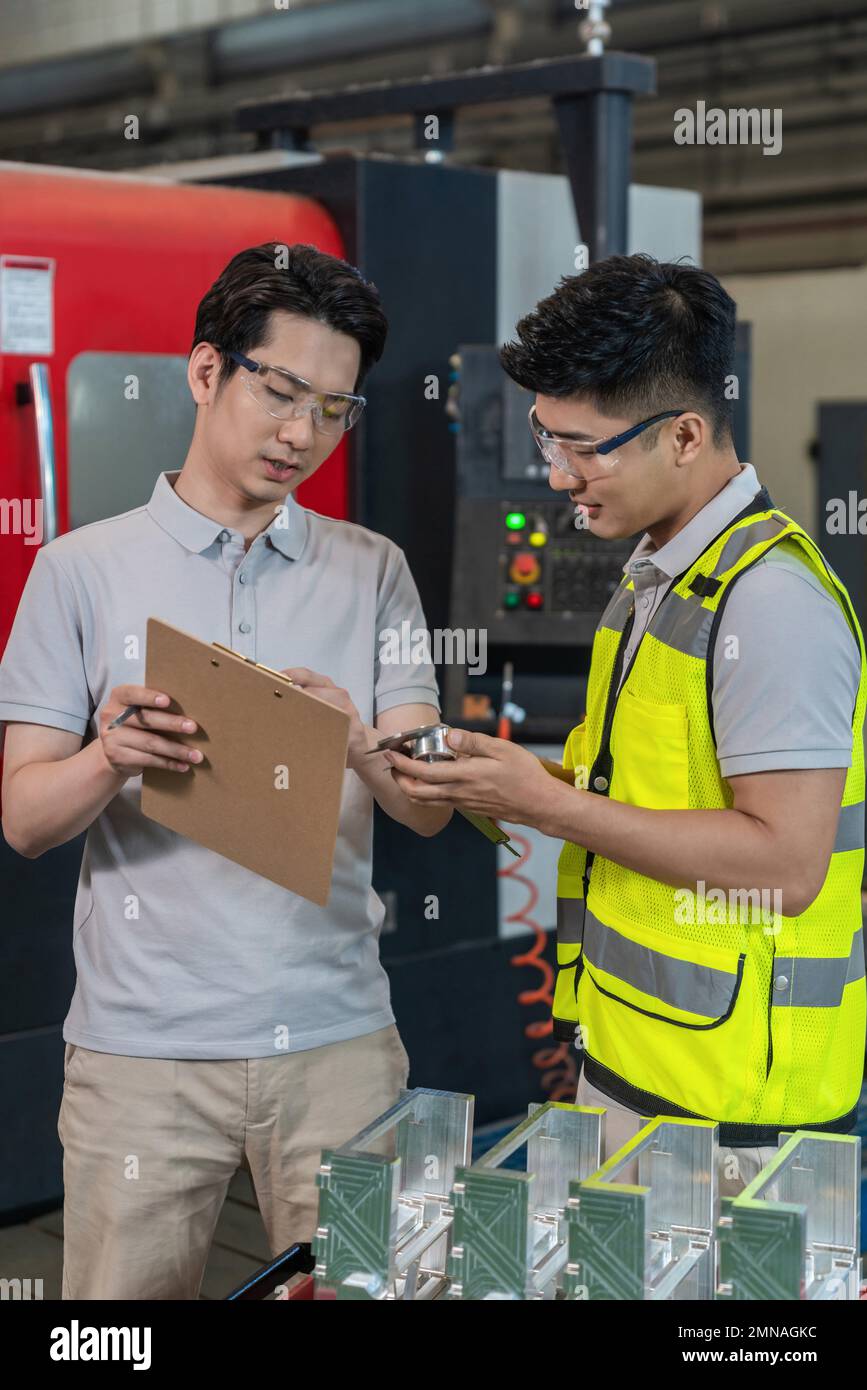 Two engineers at the factory to do measurement Stock Photo - Alamy
