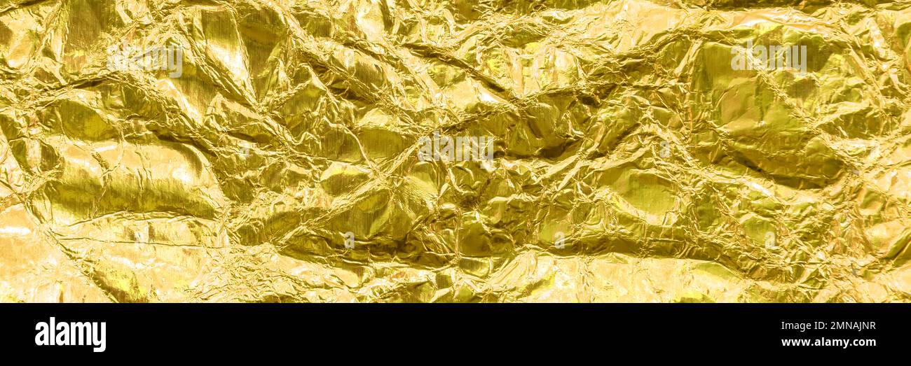 Texture of crumpled, crumpled foil of golden, yellow color. Foil banner ...