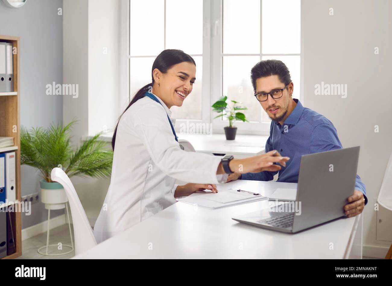 Female doctor showing test results to patient on laptop computer Stock ...