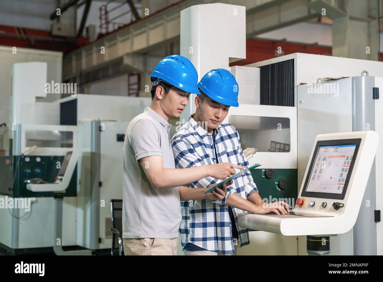 Two engineers working in the factory Stock Photo - Alamy