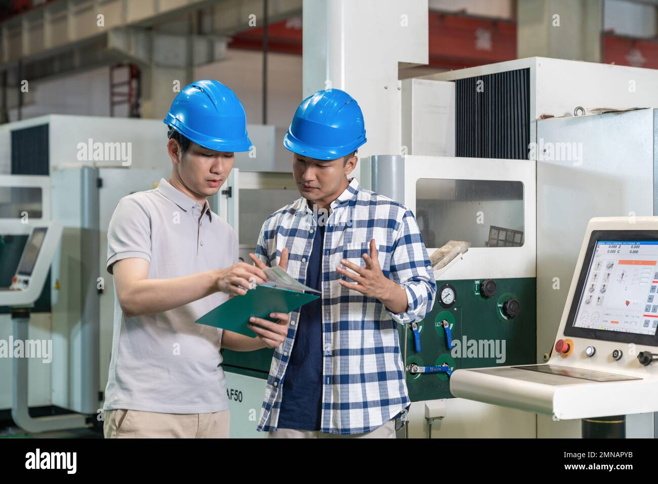Two engineers working in the factory Stock Photo - Alamy