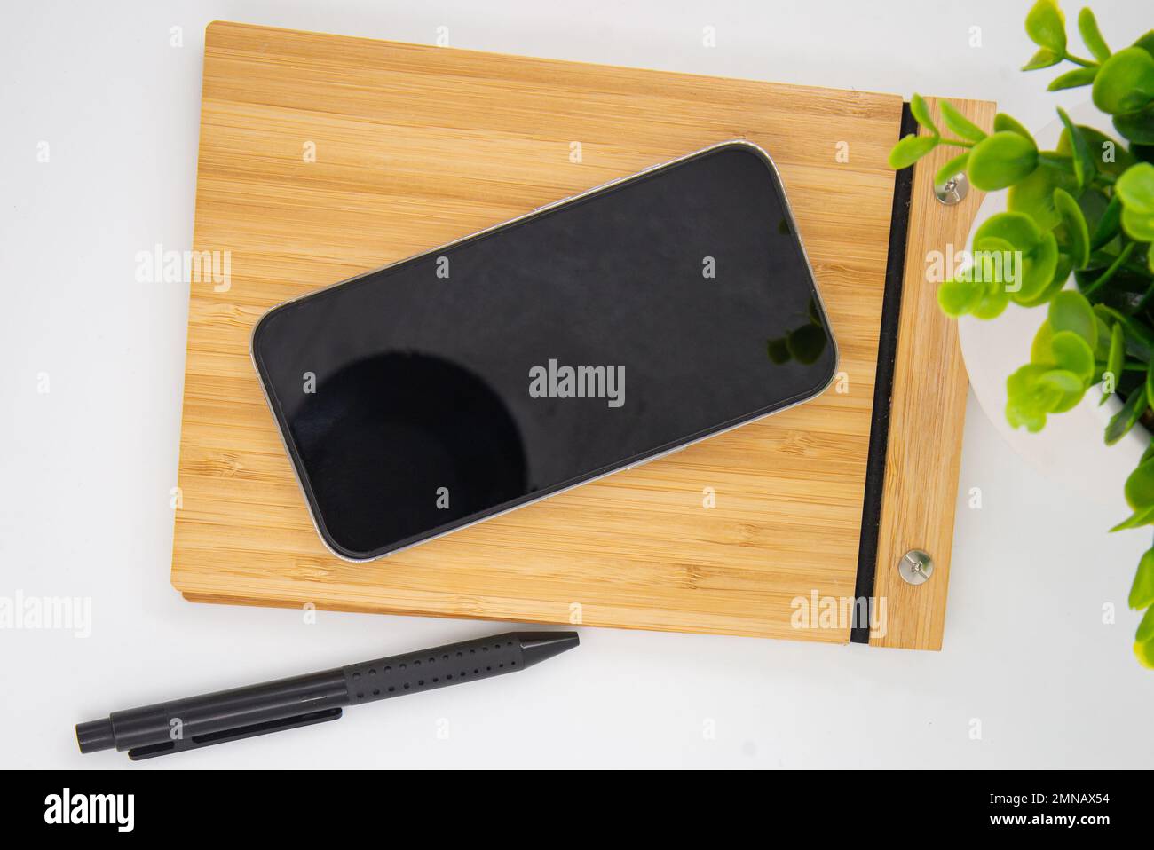 Flat lay of mobile smart phone with blank screen of gadget on notebook ...