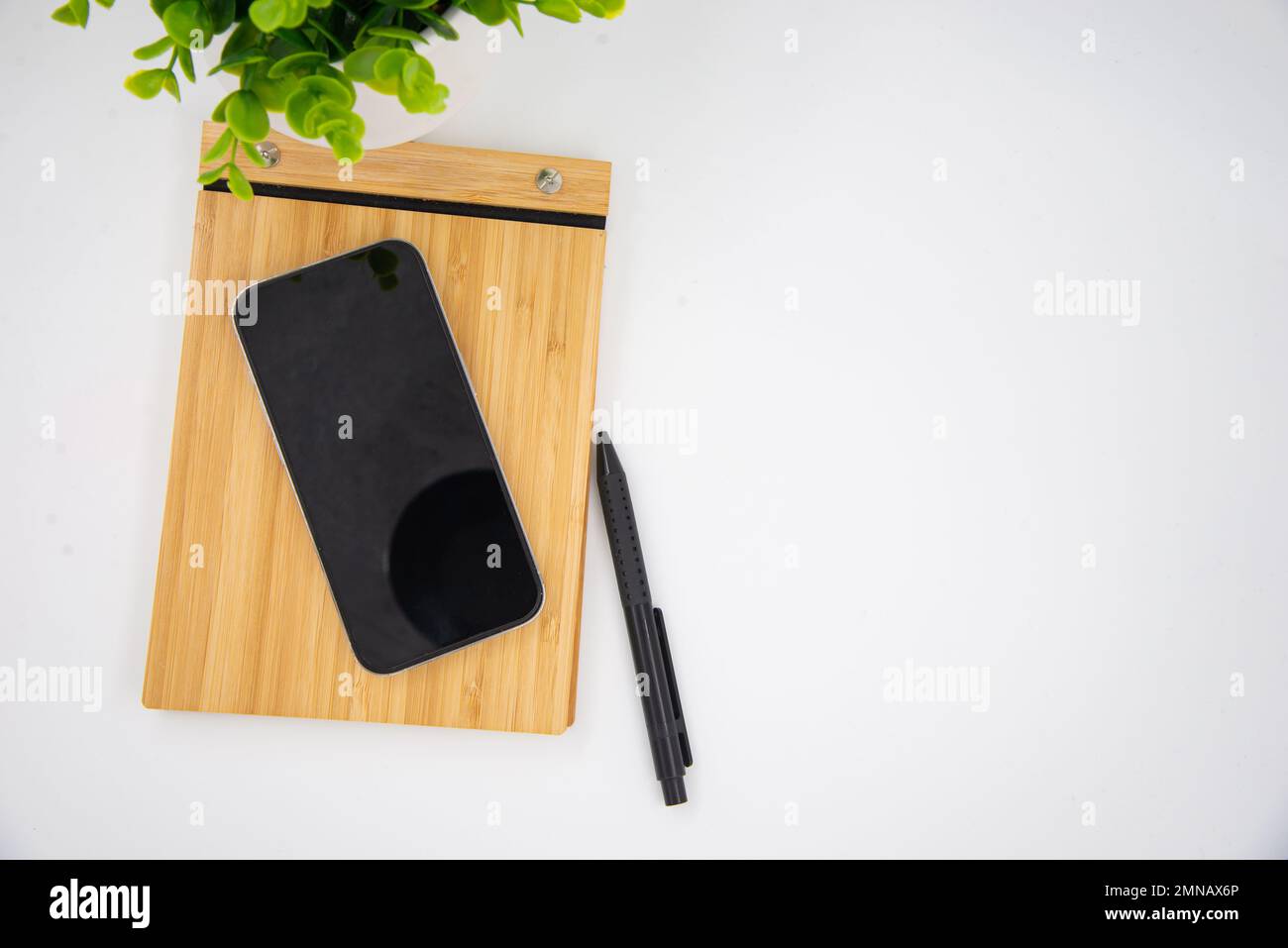 Flat lay of mobile smart phone with blank screen of gadget on notebook ...