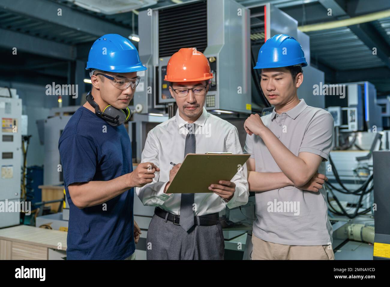 Three engineers working in the factory Stock Photo - Alamy