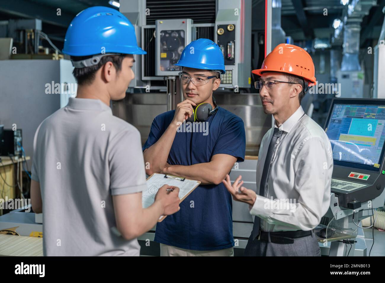 Three engineers working in the factory Stock Photo - Alamy