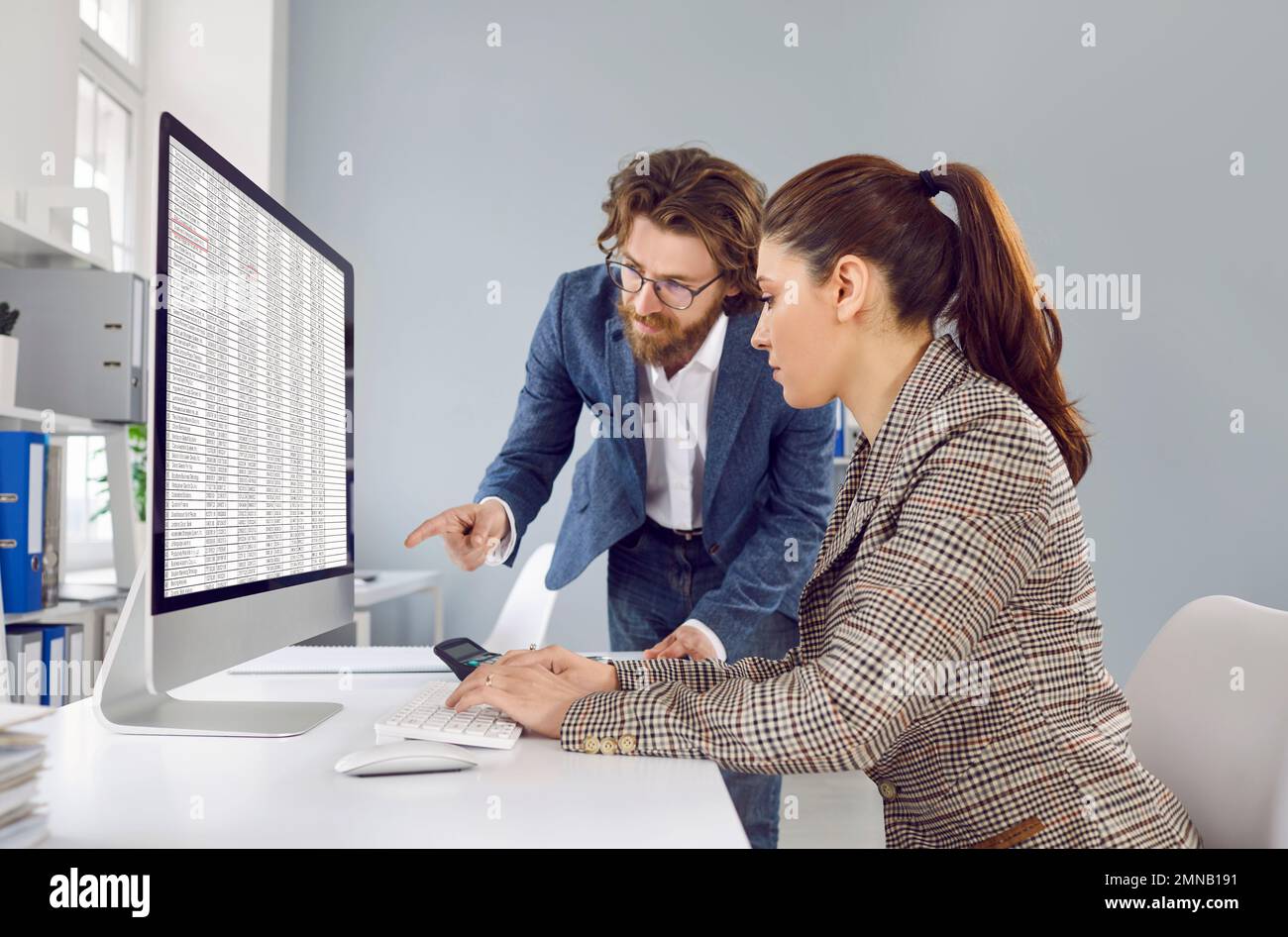 Two accountants working in office and looking at business spreadsheets ...