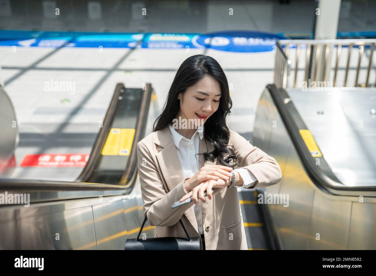 Business lady sit elevator watch at the airport Stock Photo - Alamy