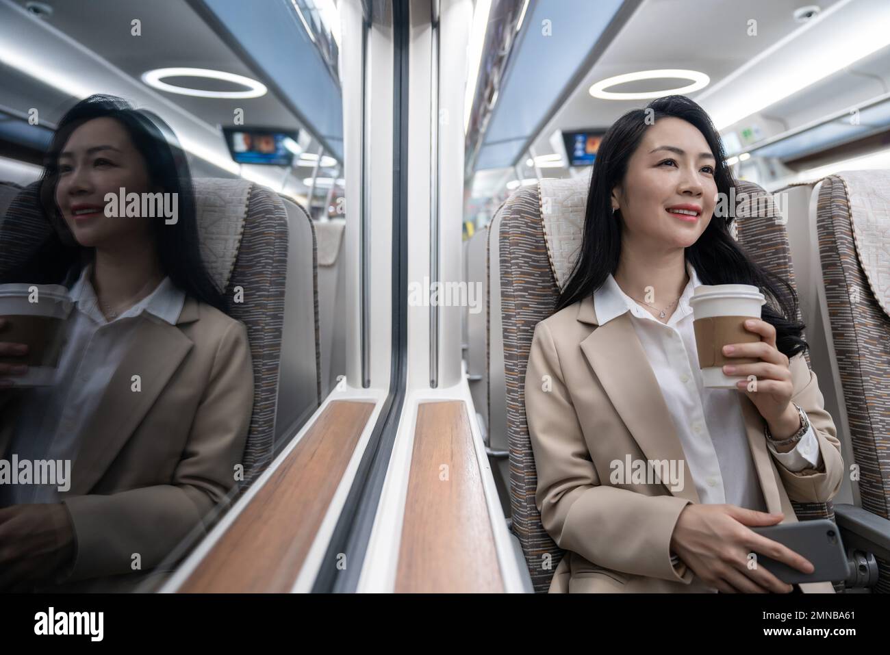 Ms business take the subway with a cup of coffee Stock Photo - Alamy