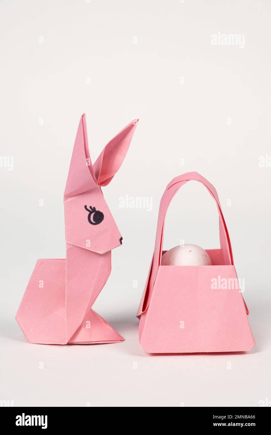 Easter origami bunny and a basket of eggs on a white background. Paper ...