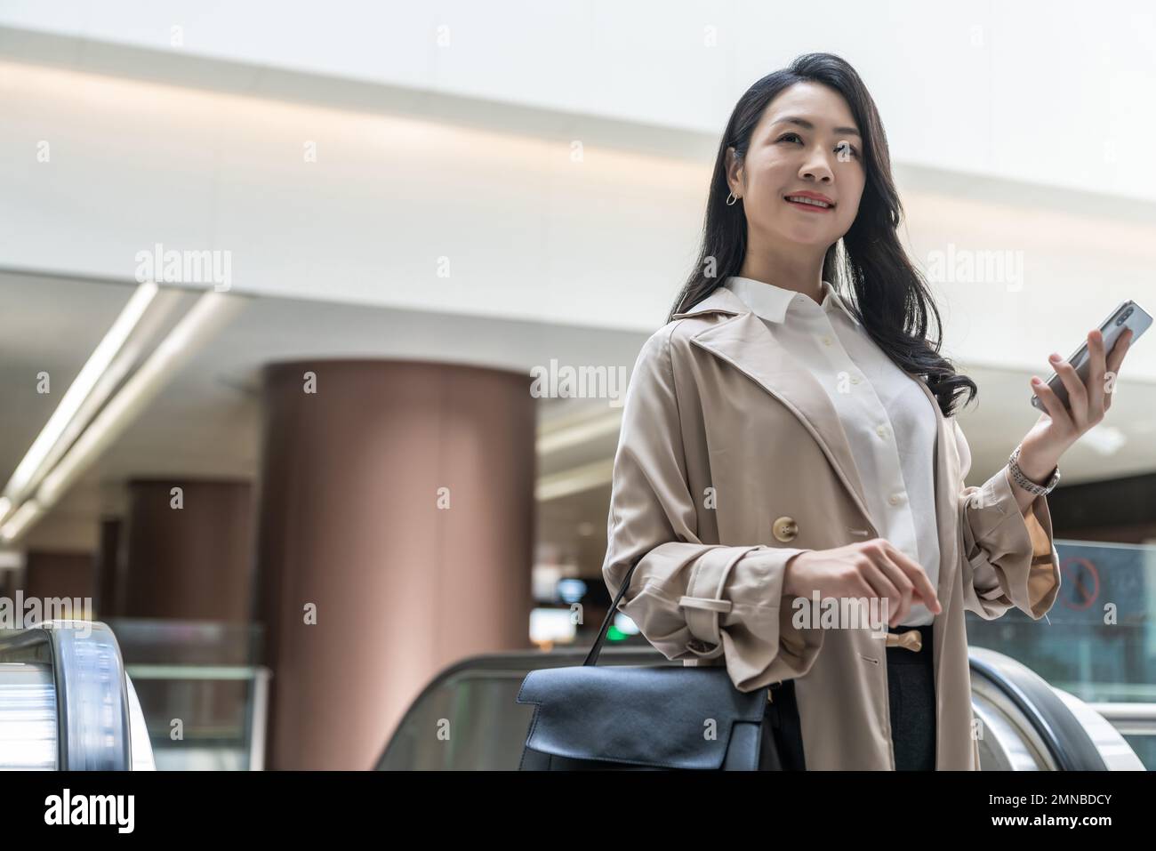 Ms business using mobile phones to ride the elevator at the airport ...