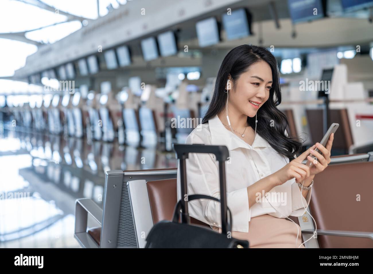 Ms business use of mobile phones at the airport Stock Photo - Alamy