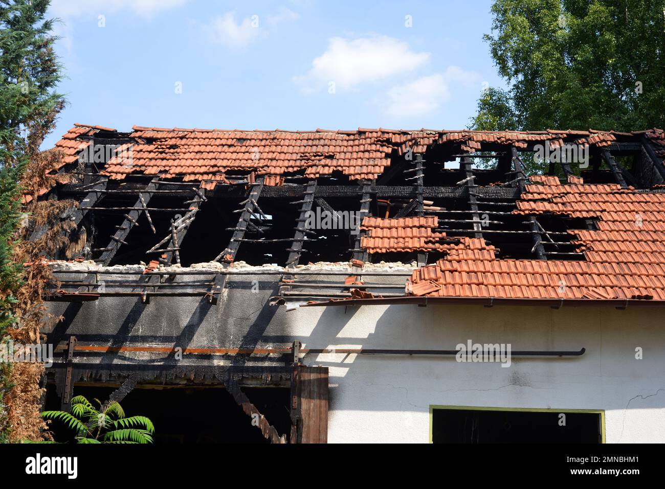 Burned house with holes in roof and building structure Stock Photo - Alamy