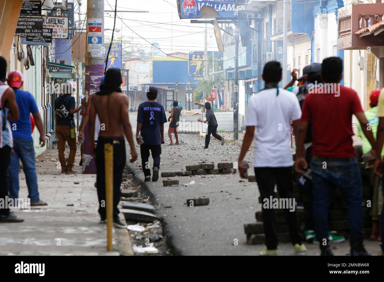 Protestors throw rocks as they clash with riot police in the Monimbo ...