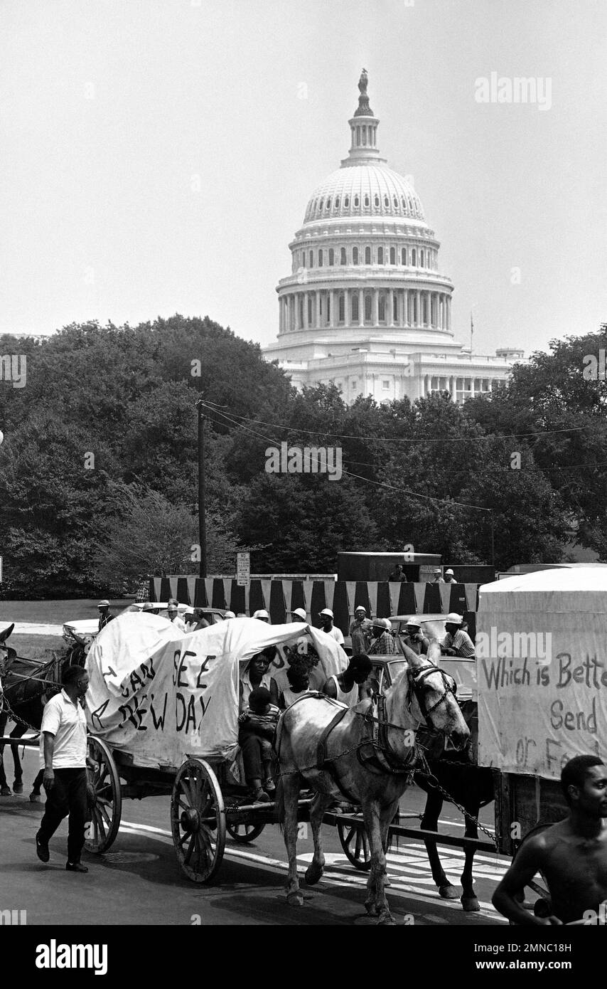 FILE -In this June 25, 1968 photograph, people walk beside wagons of ...