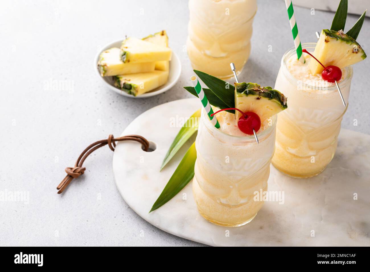 Tropical pina colada cocktail or mocktail in a tiki glass with ...
