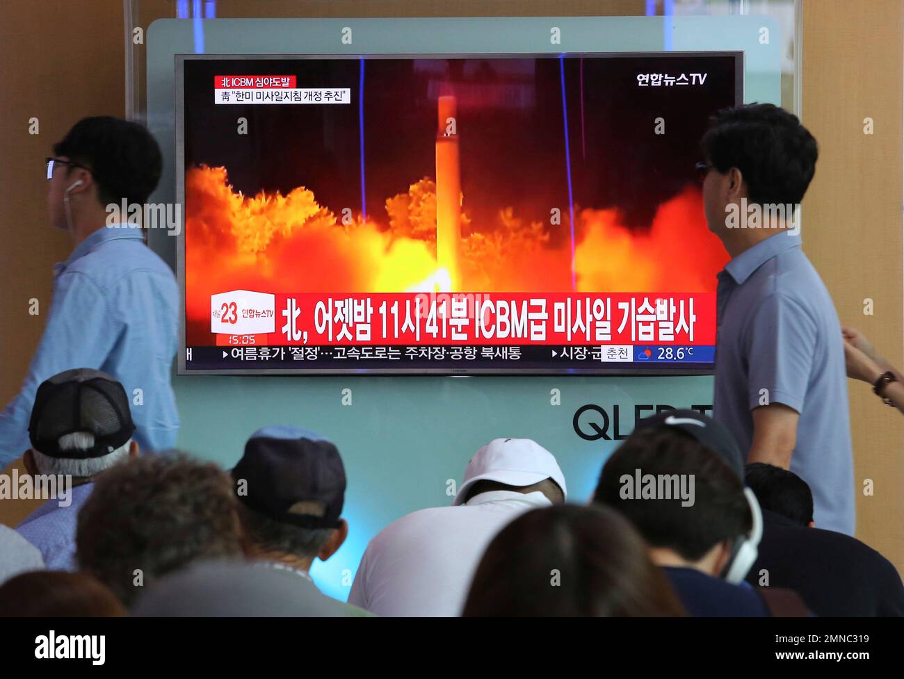 FILE - In this July 29, 2017, file photo, people watch a TV news program showing an image of ...