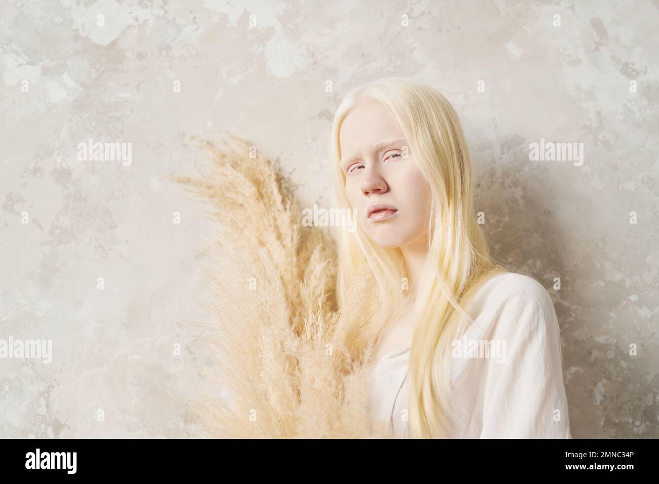 Portrait of natural beauty of peaceful albino girl holding bouquet of ...