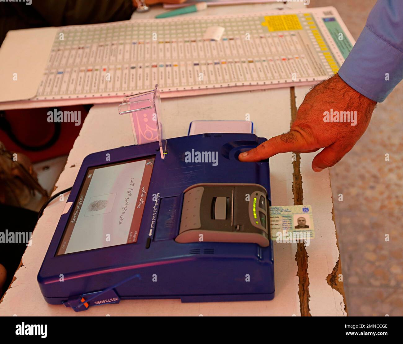 An Iraqi Federal policeman gives his fingerprint before casting his ...